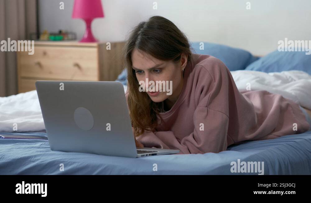 young woman using a laptop computer on bed Stock Video Footage - Alamy