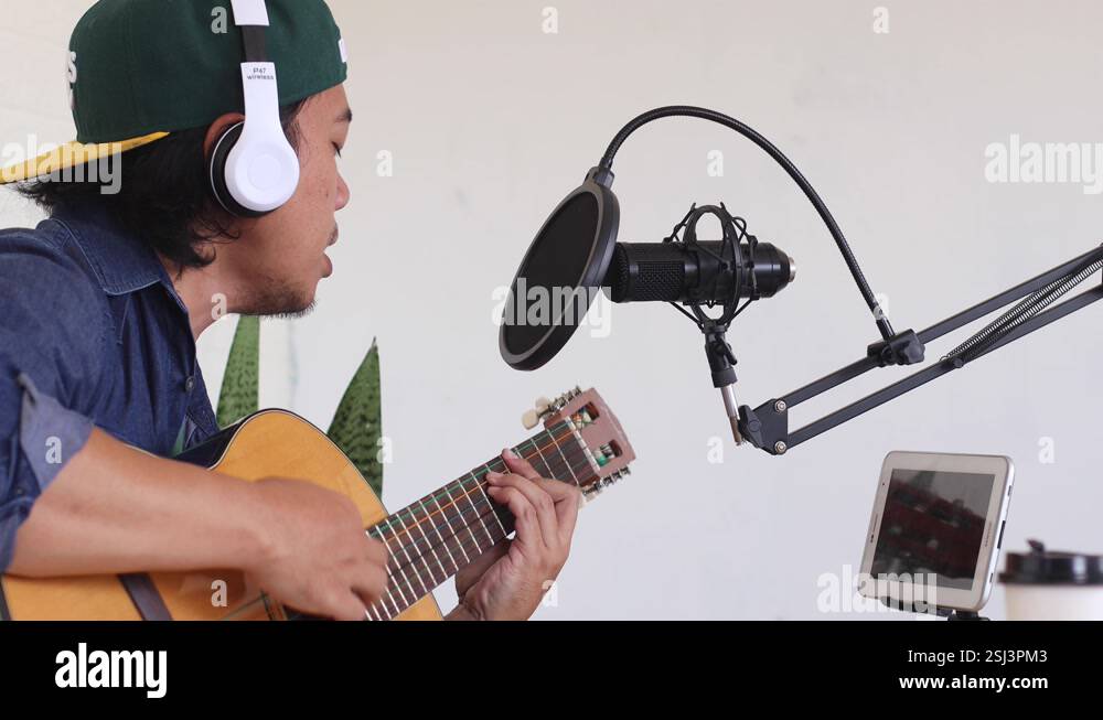 Asian influencer playing guitar during podcast or live video at home studio Stock Video Footage ...