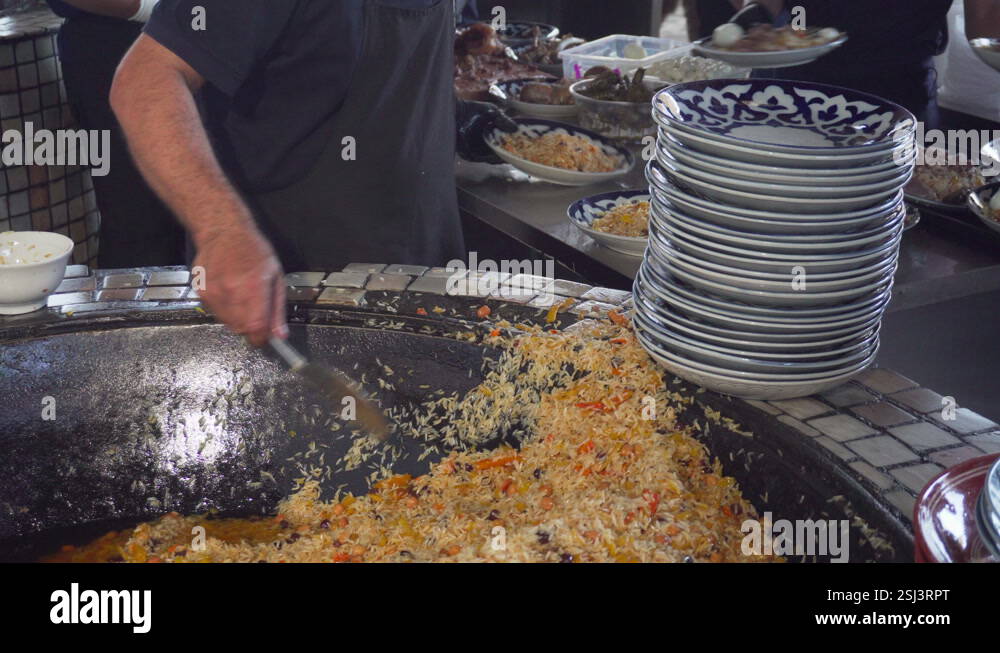 Cookers are putting plov (pilaf) on plates, Tashkent, Uzbekistan Stock ...