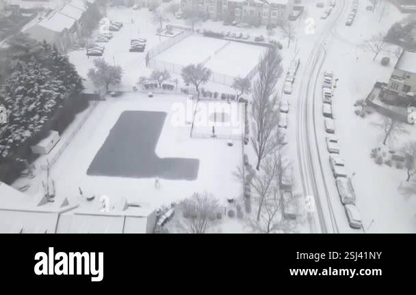 Blizzard, residential homes and trees during winter snowfall. Drone ...