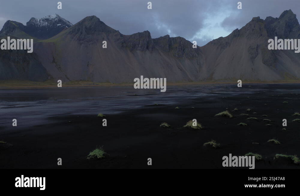 Aerial: Slow panning shot of Vestrahorn at Stokksnes peninsula during ...