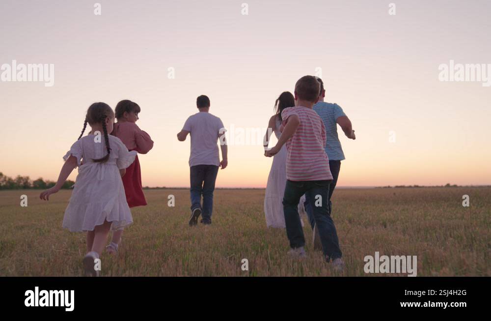Children, child, together with their parents run in park, sunset. Dad ...