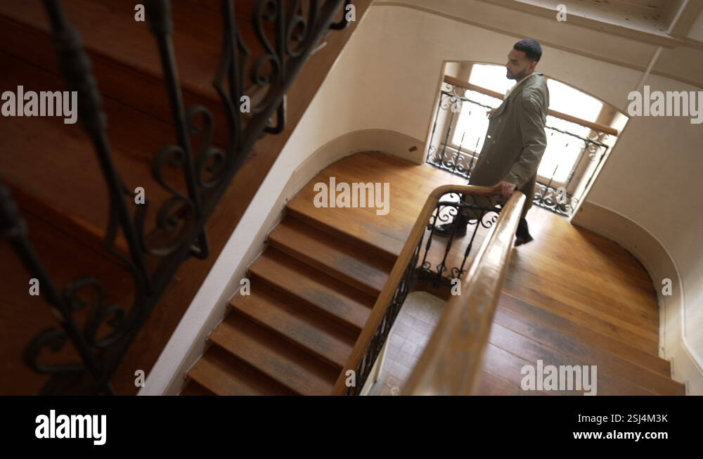 Man going down the stairs, person leaving building wearing jacket Stock ...