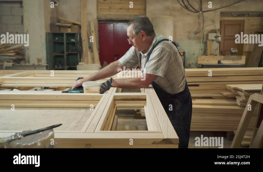 Foreman carpenter is assembling the wooden product at the Industrial ...