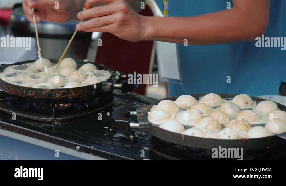 street vendors at a festival are cooking takoyaki in a krok pan Stock ...