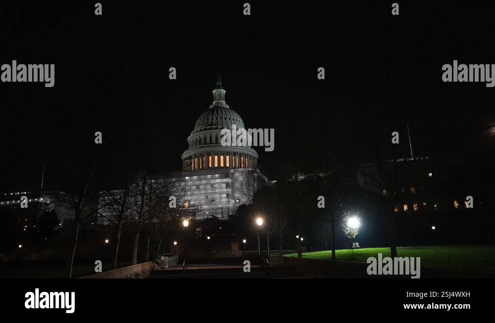 Camera pulling away from the US Capitol building at night showing ...