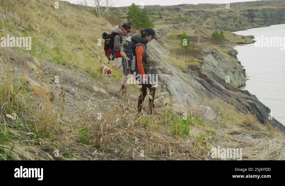 Lateral View Of Two Young Female Tourists Coming Down Rocky Slope To ...