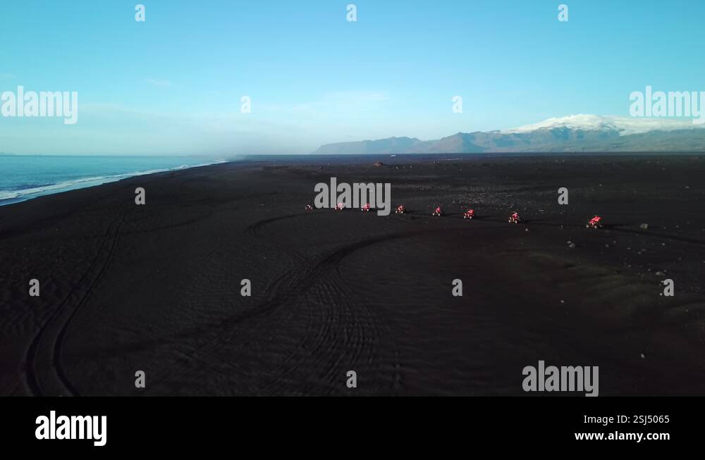 Aerial panoramic seascape view of people riding red quad bikes on the ...