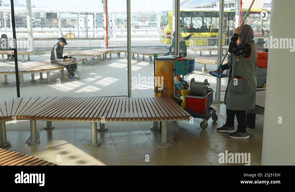 Public transport worker cleaning the bus station terminal. Muslim woman ...