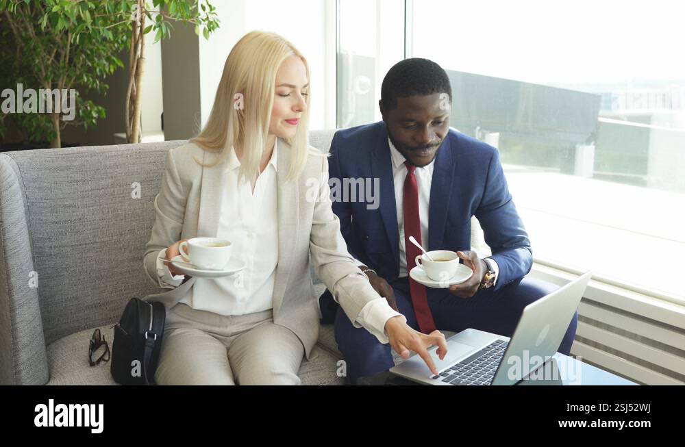 Business coworking of two different people, a man from Africa and a ...