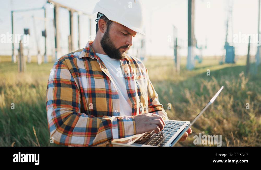 Engineer walk on field with electricity towers. Electrical engineer ...