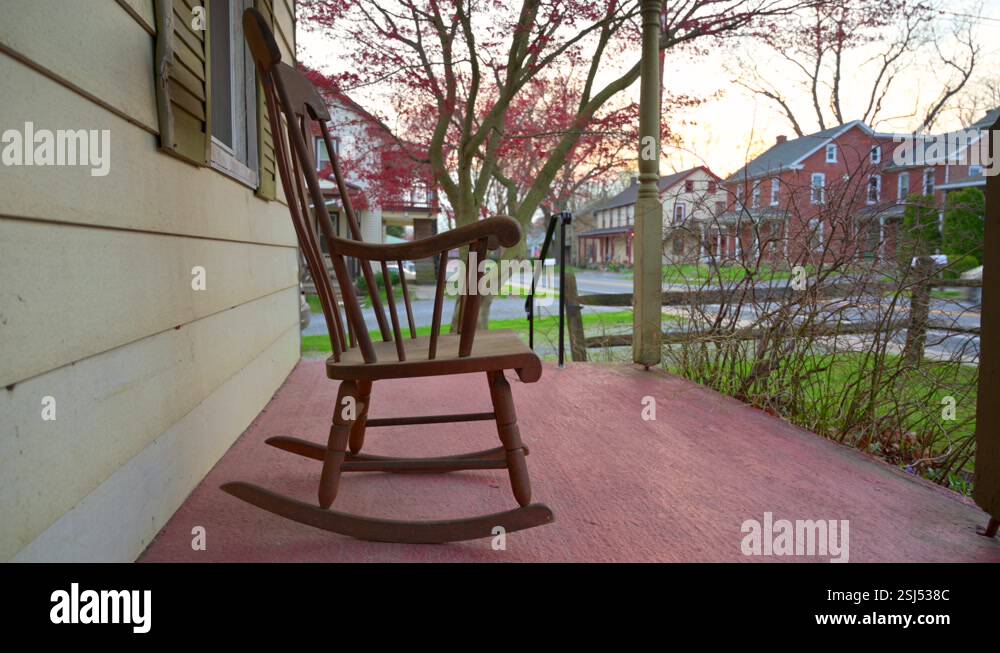 Rocking chair blowing in wind on front porch during sunset Stock Video ...