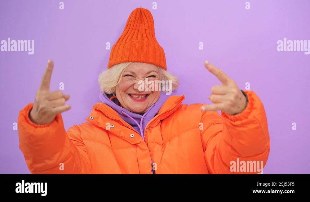 A modern woman of retirement age enjoys her age with a smile, posing in ...