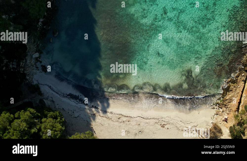 Shadows cast over beach along Menorca's coastline in Spain at sunset ...