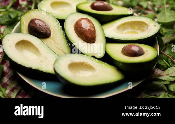 A plate filled with numerous fresh avocado halves, showcasing their ...