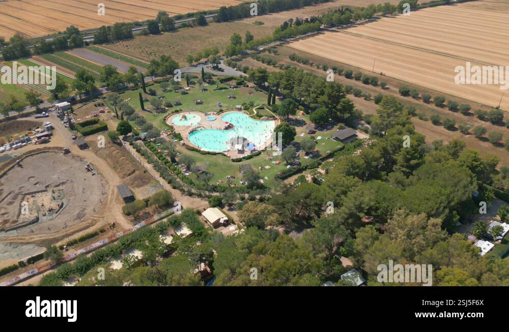 Sweeping overview of pool, agriculture field, and campsite in Le ...
