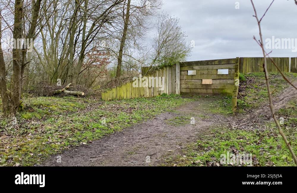 Wooden bird hide in countryside field with deciduous trees in fall ...