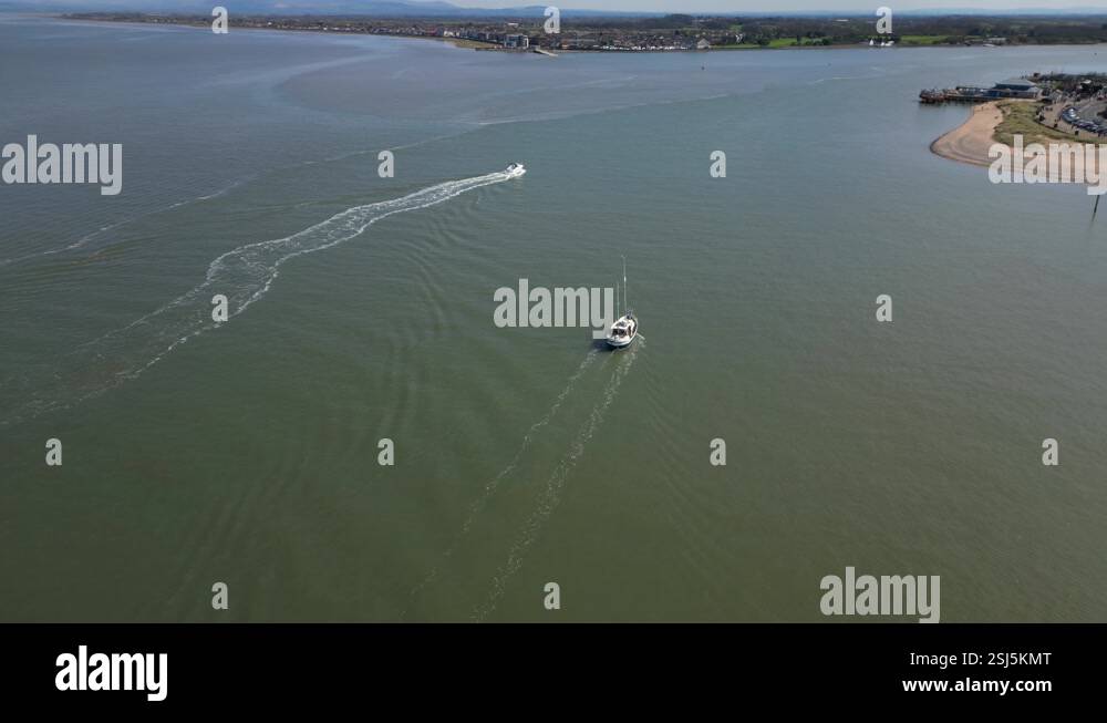 Speedboat and yacht nearing river mouth with port town reveal at ...