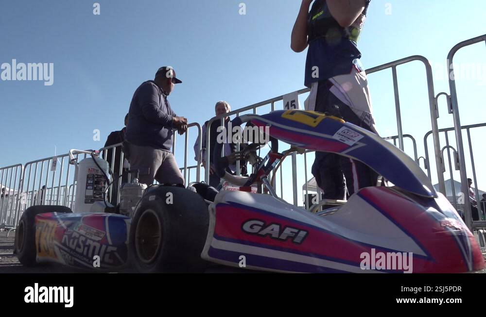 Slow motion dolly of a go-kart driver getting prepared to race in the ...
