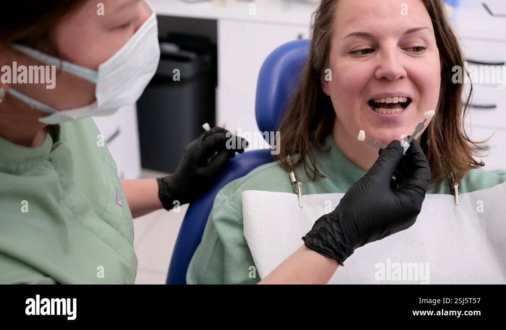 Dentist hand holding teeth color samples helping patient teeth ...