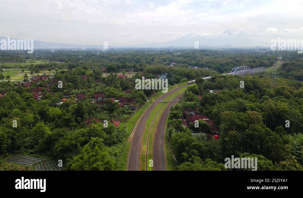 Aerial view of a train running on rails crossing the bridges in the ...