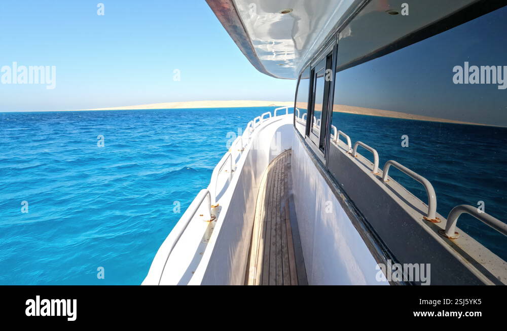 Shot of a luxury yacht sailing over deep blue sea at daytime. Side view ...