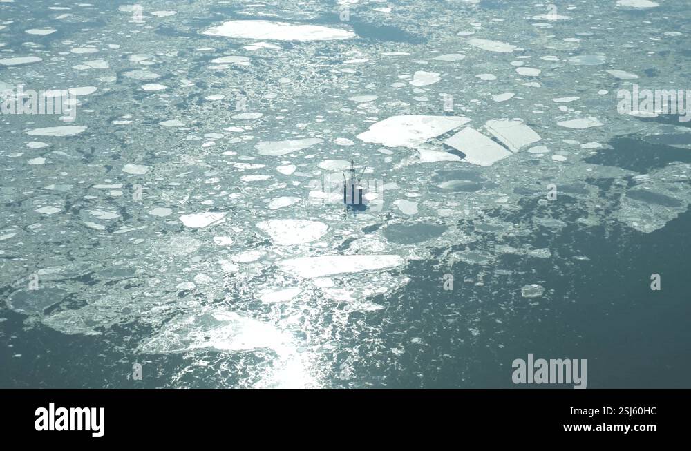 Flight over the icy waters Cook Inlet in Alaska during winter with vast ...