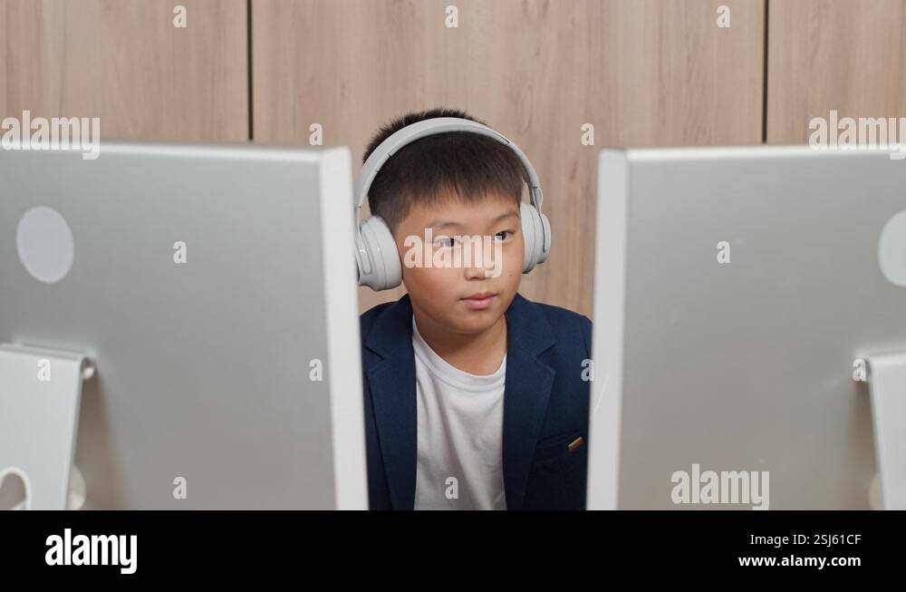Asian boy working on a PC while sitting at a desk at home, a teen boy ...