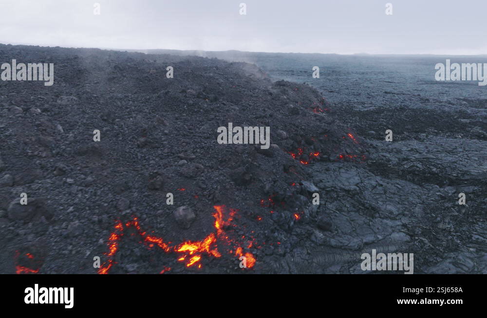 Breathtaking aerial drone of red hot lava flowing and freezing with ...