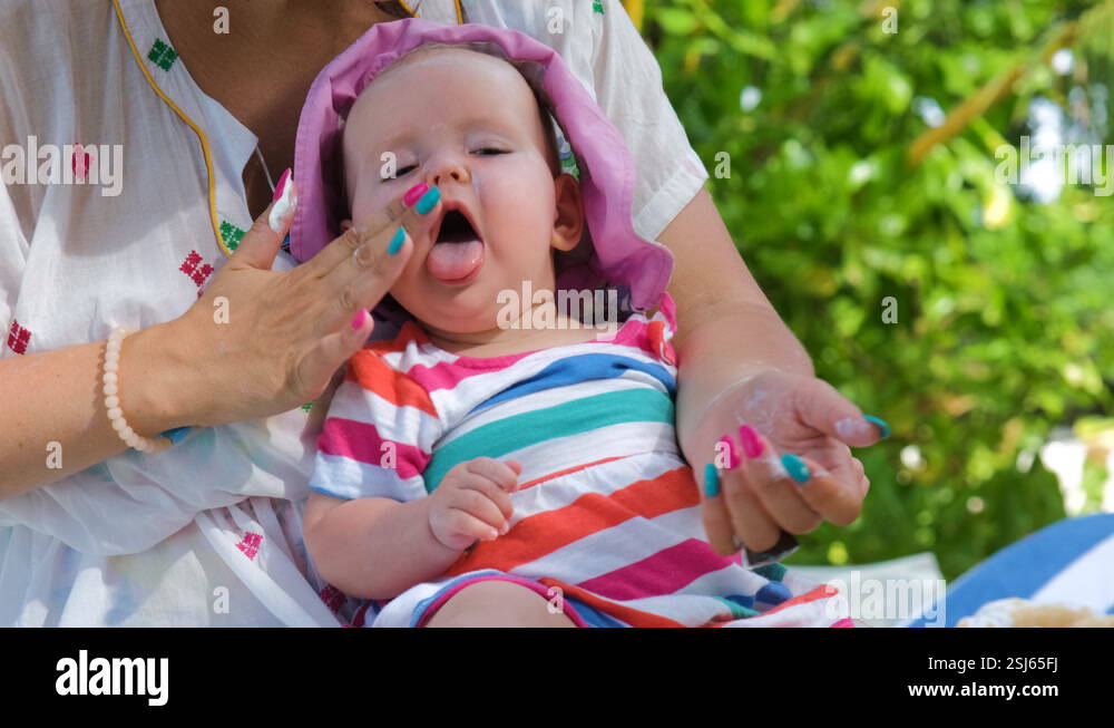 Mother using sunblock lotion to protect baby Stock Video Footage - Alamy