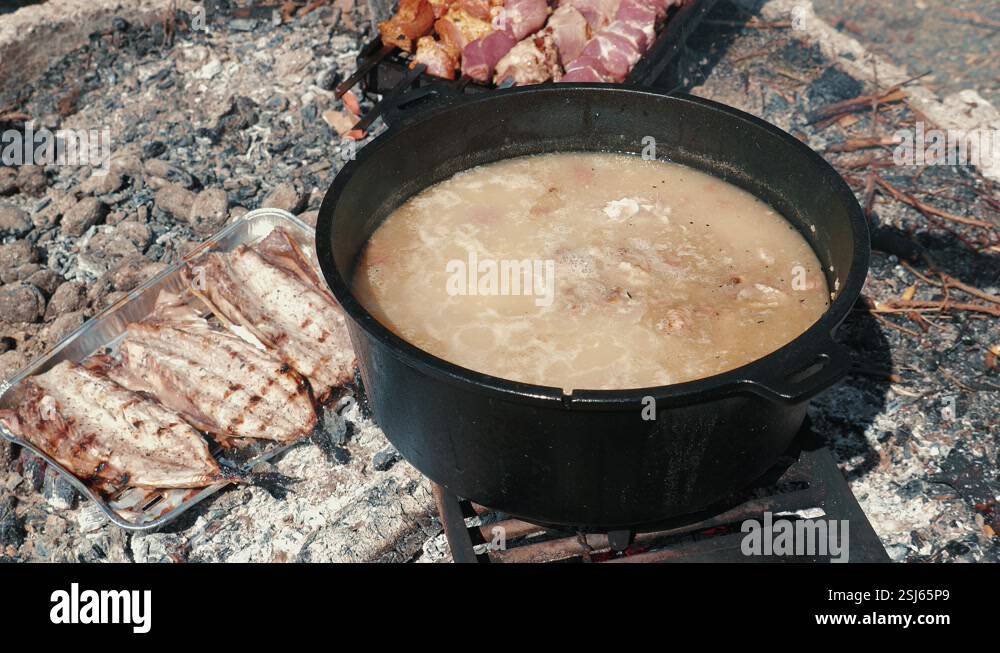 Cauldron with kulish prepared on fire. Picnic time. Barbecue meat ...