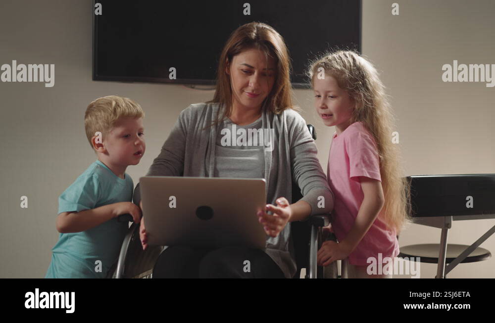 Curious children watch freelance mother working on laptop Stock Video Footage - Alamy