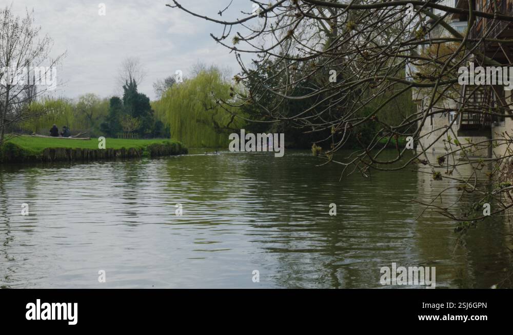 Water flows down calm river as tour guide pushes boat by beautiful ...