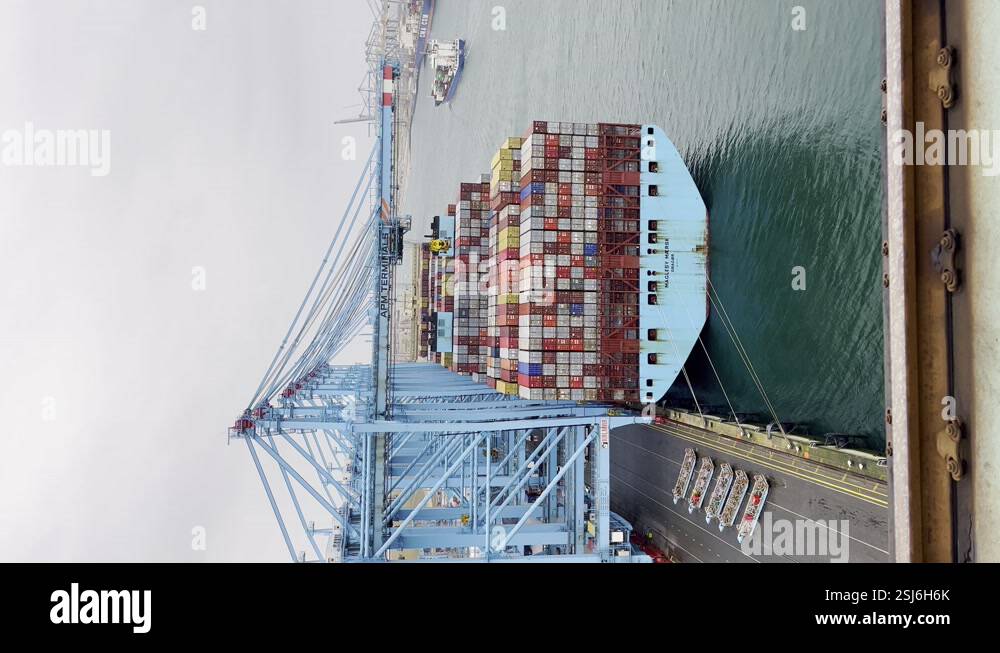 Vertical video of a container crane loading containers on the giant ...
