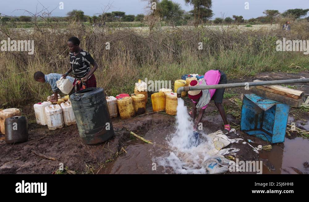 Masai people gather drinkable water from borehole well in Kenya. Water ...