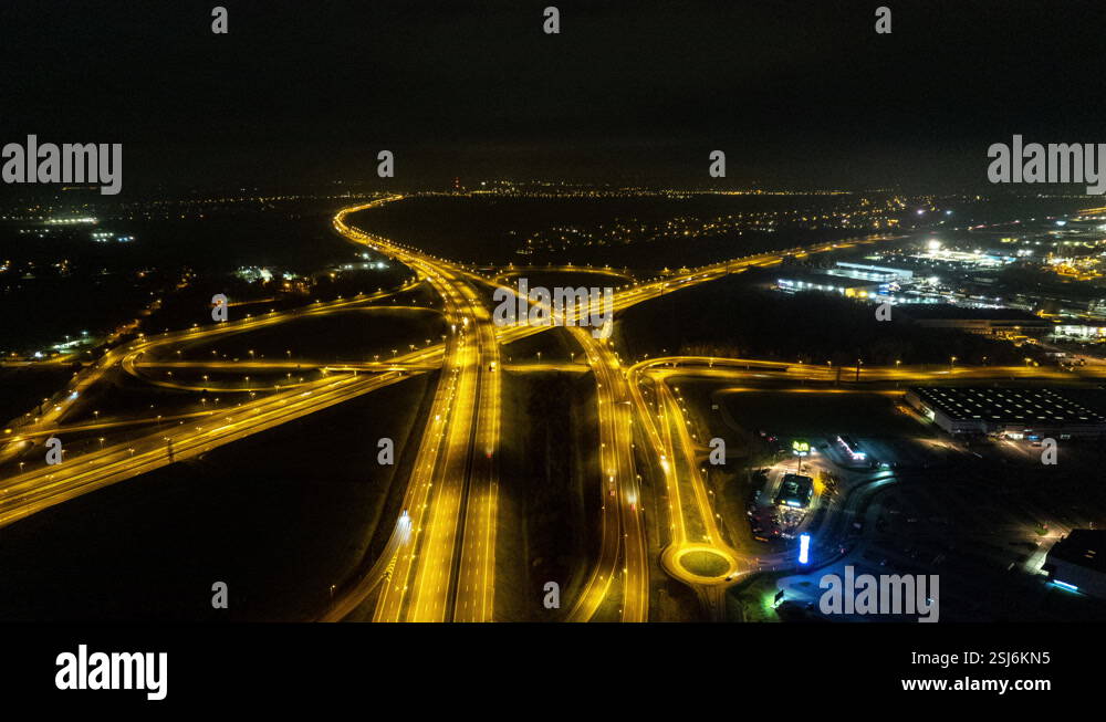 Aerial Hyperlapse of highway intersection at night with cars and ...