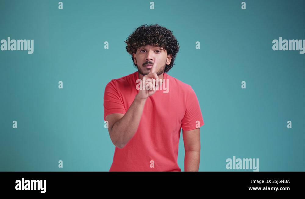 Shh be quiet please. Young indian man presses index finger to lips ...