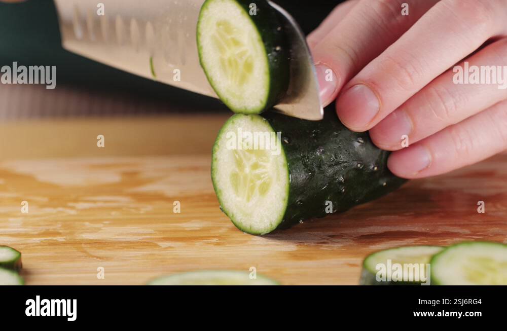 Slicing cucumber vegetables with a knife for cooking, chef cut ...