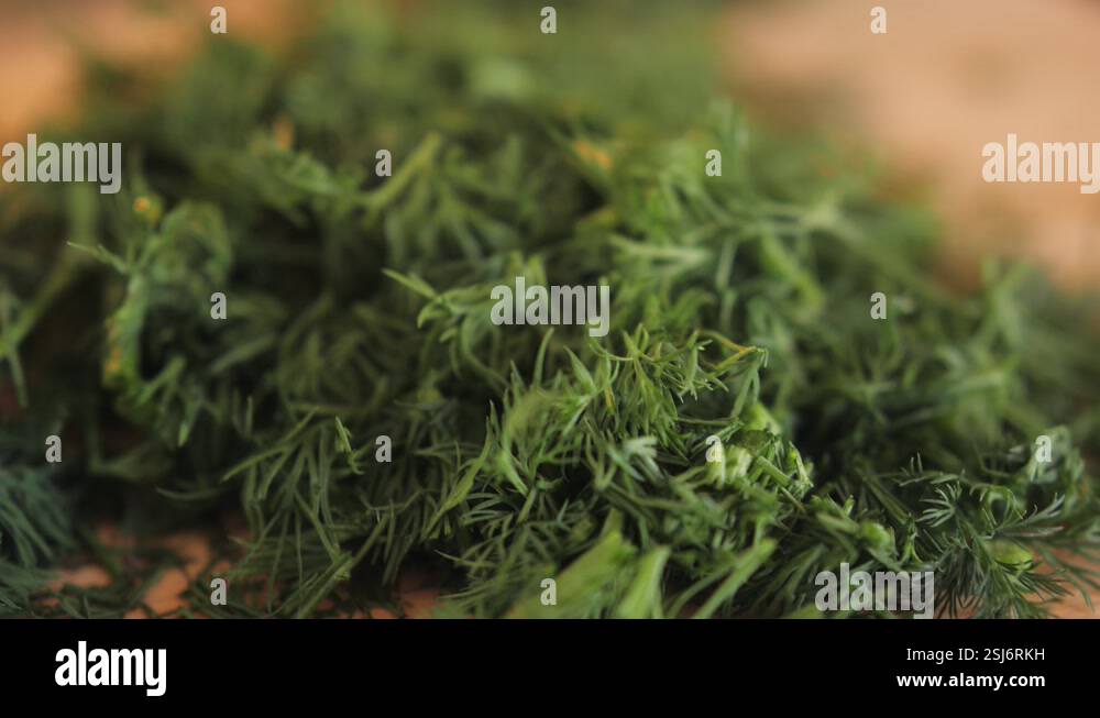 Cutting dill, chef cut dill with knife on a wooden board, close up at ...