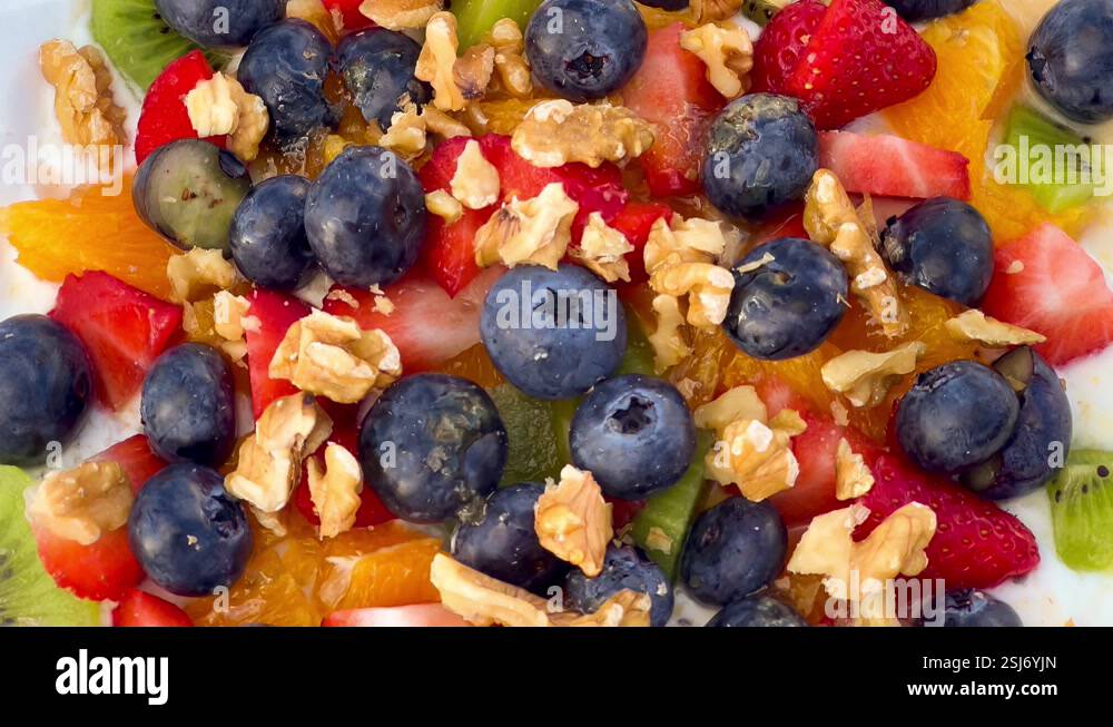 Healthy breakfast strawberries, raspberries, blueberries, kiwi, orange ...