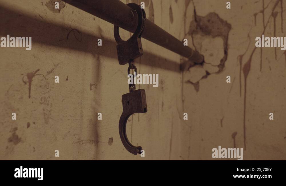 The handcuffs chained to a pipe in an old abandoned building or horror ...