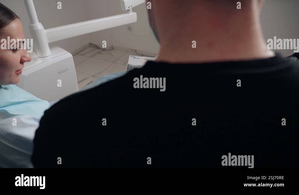 male dentist with face mask examining teeth of female patient at modern dent Stock Video Footage ...