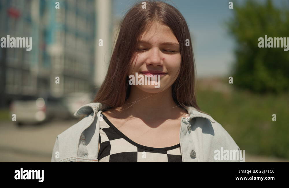 Girl stands near high-rise building closing eyes dreamily Stock Video ...