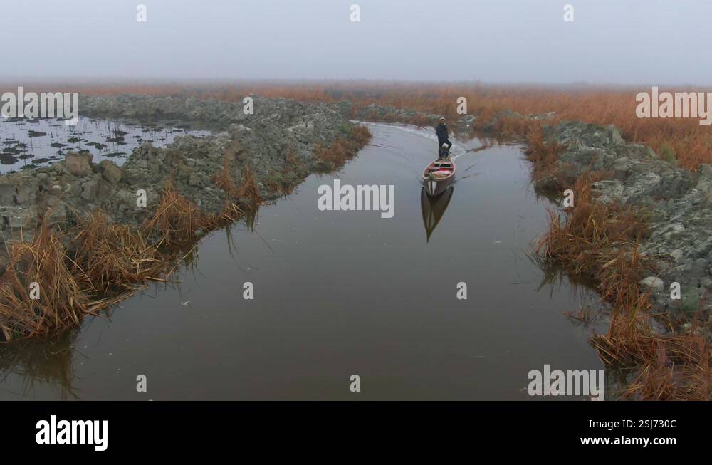 Fisherman Worker on Canoe Boat Sailing Along Mesopotamian Marshes in ...