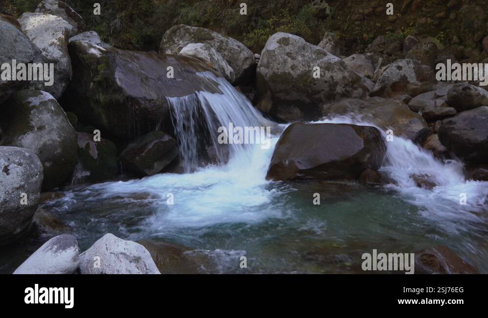 A small stream tumbling over rocks making a small waterfalls in the ...