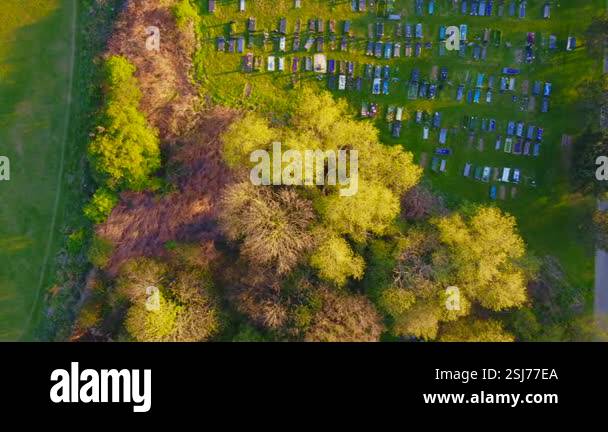 4k drone footage panning over a line of trees separating a graveyard ...