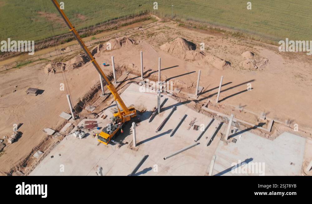 Construction of a hall, concrete floor, columns, and a standing crane ...