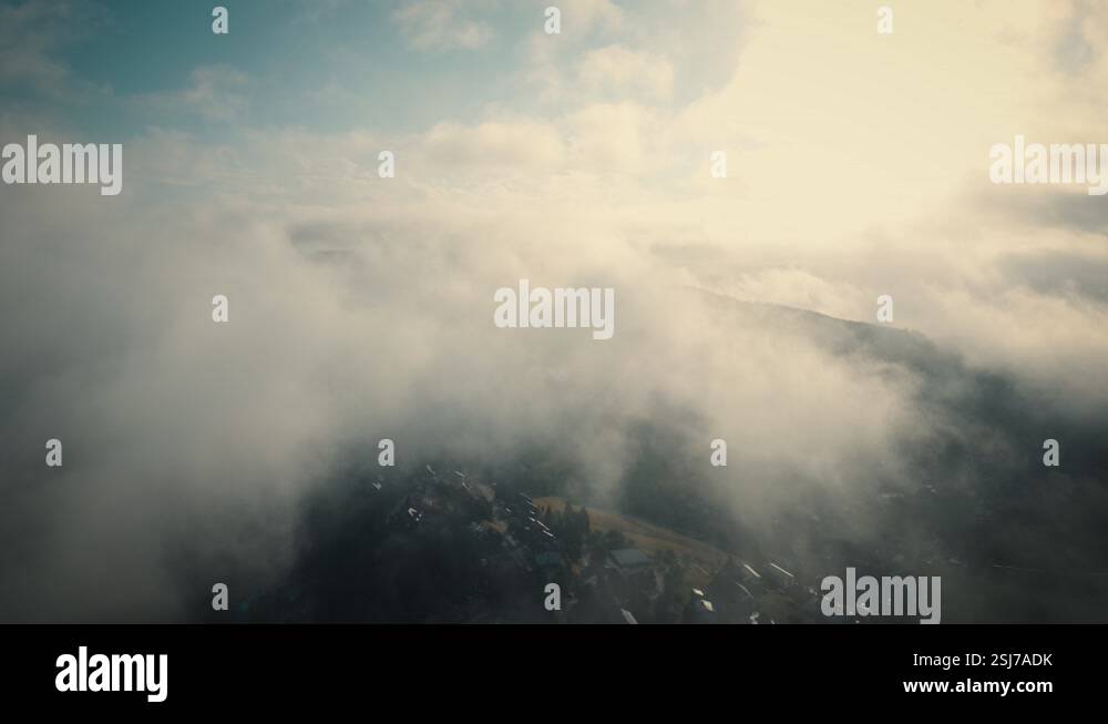 Sunny morning. Aerial descending among clouds over mountains Stock ...