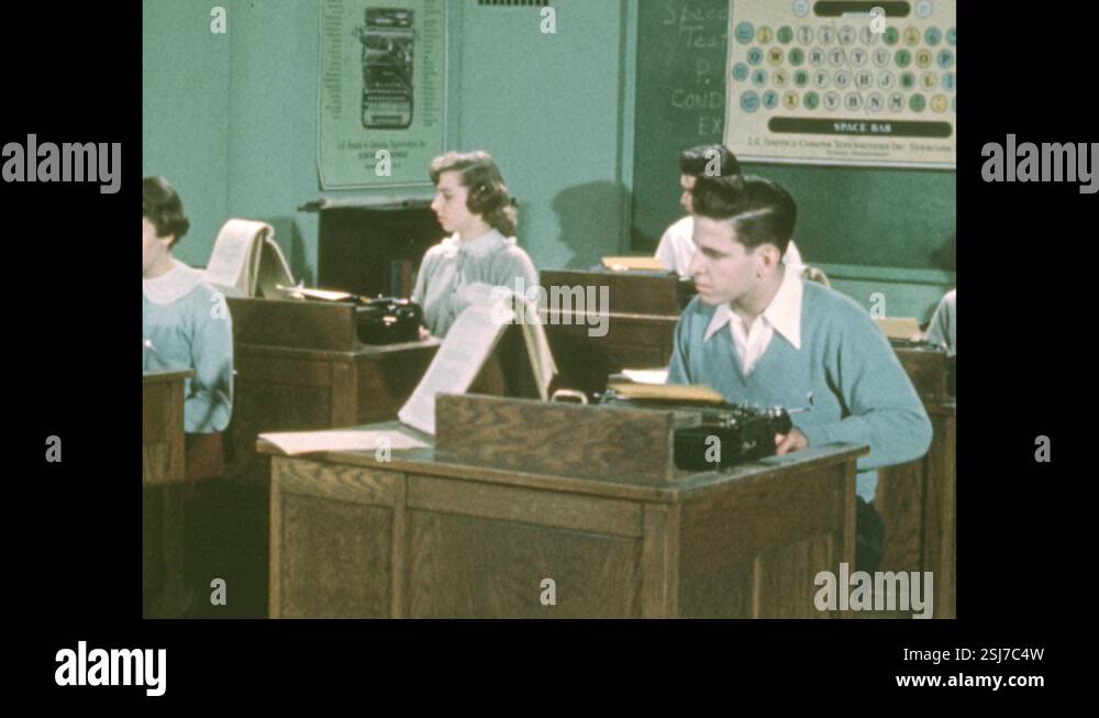 1950s: Students work in typing class. Teacher talks to students as they ...
