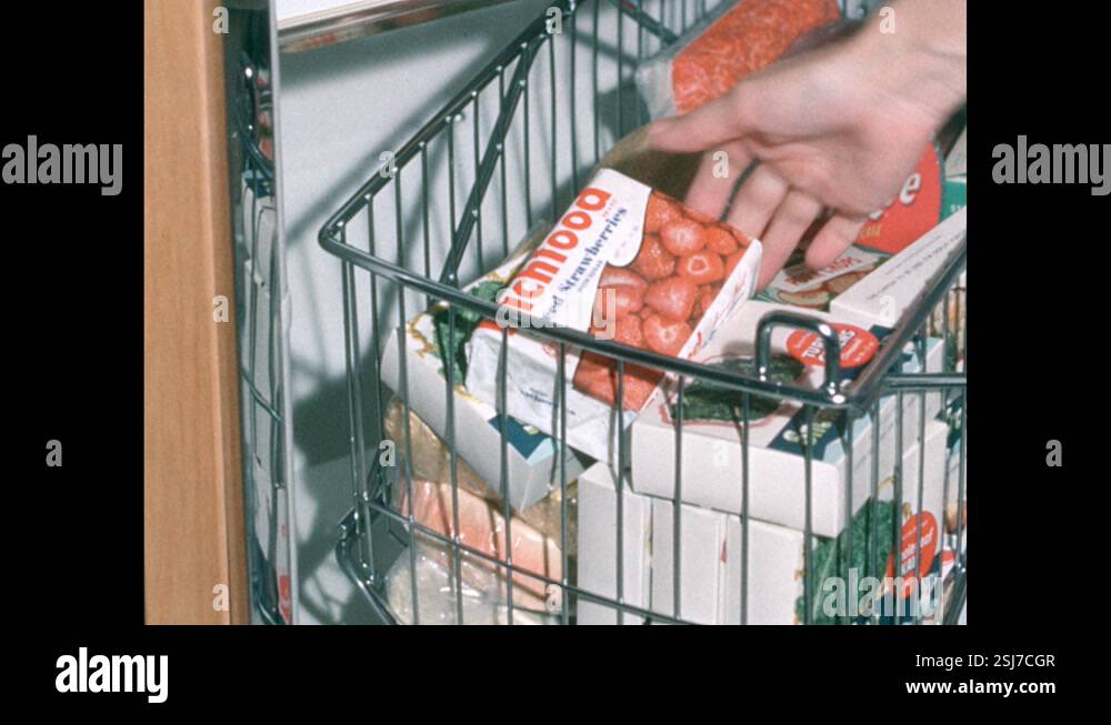 1960s: Hand with clapboard, hands open freezer, take out package of ...
